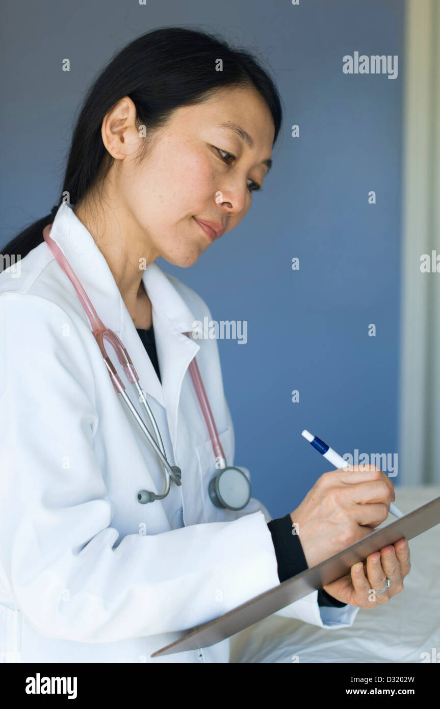 Japanese doctor writing on clipboard Stock Photo - Alamy
