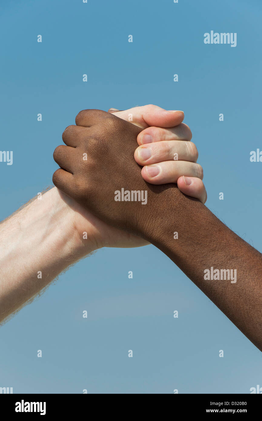 Indian and English hands. Western and Eastern hand shake against a blue ...