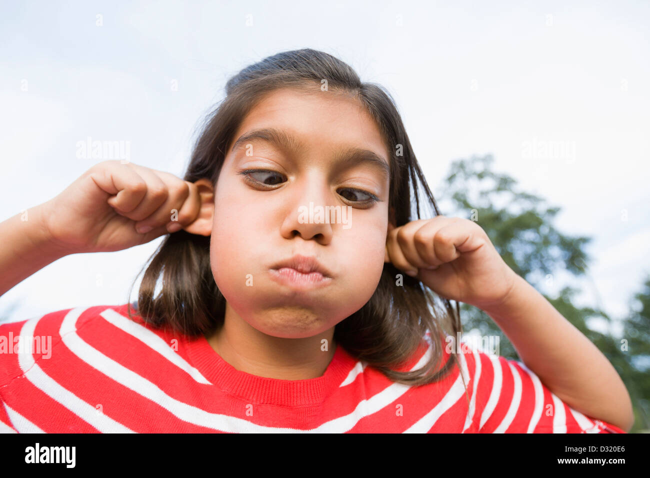 Hispanic girl making face outdoors Stock Photo - Alamy