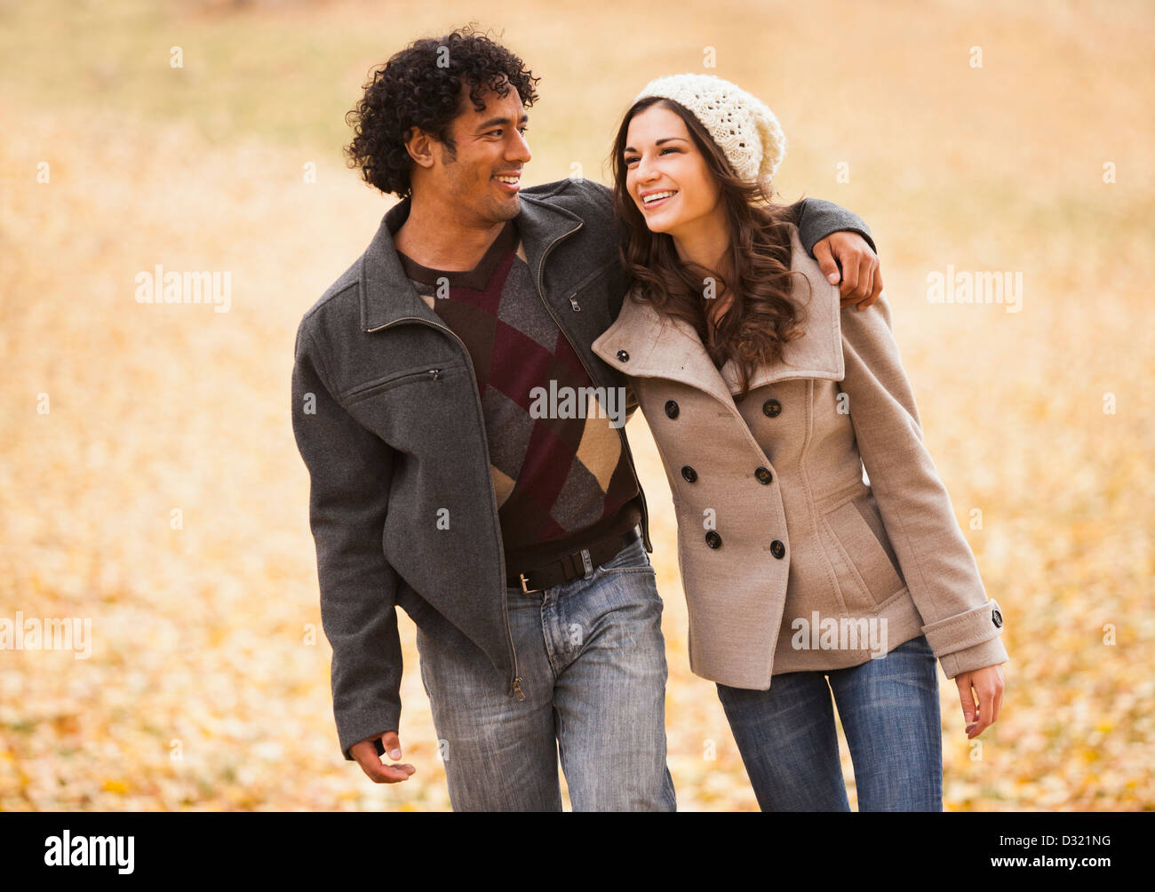 Couple walking in autumn leaves Stock Photo - Alamy