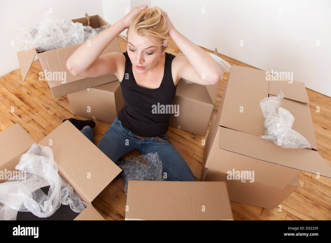 Caucasian woman unpacking boxes in new home Stock Photo - Alamy