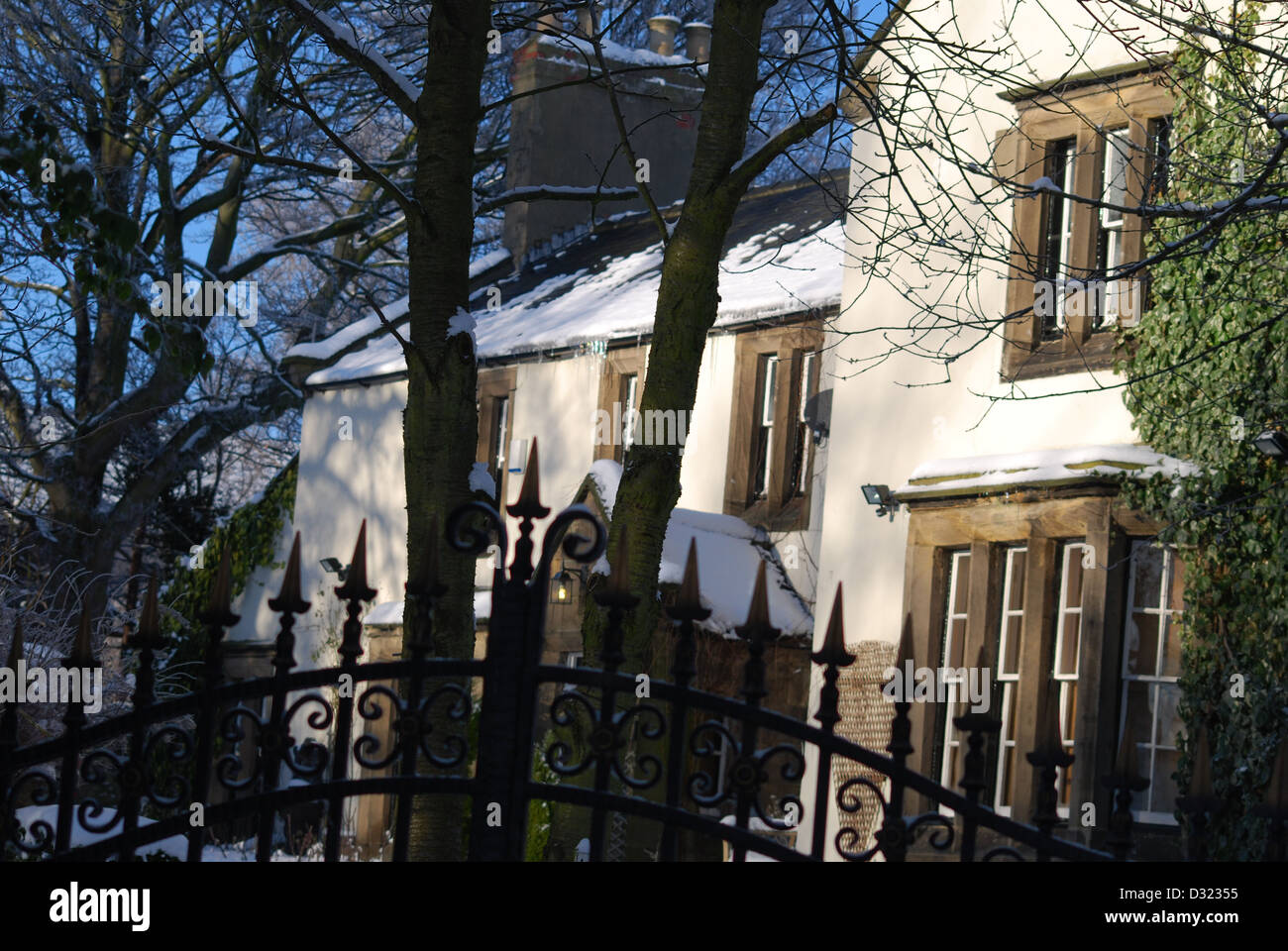A country house manor mansion in winter with snow on the roof shot ...