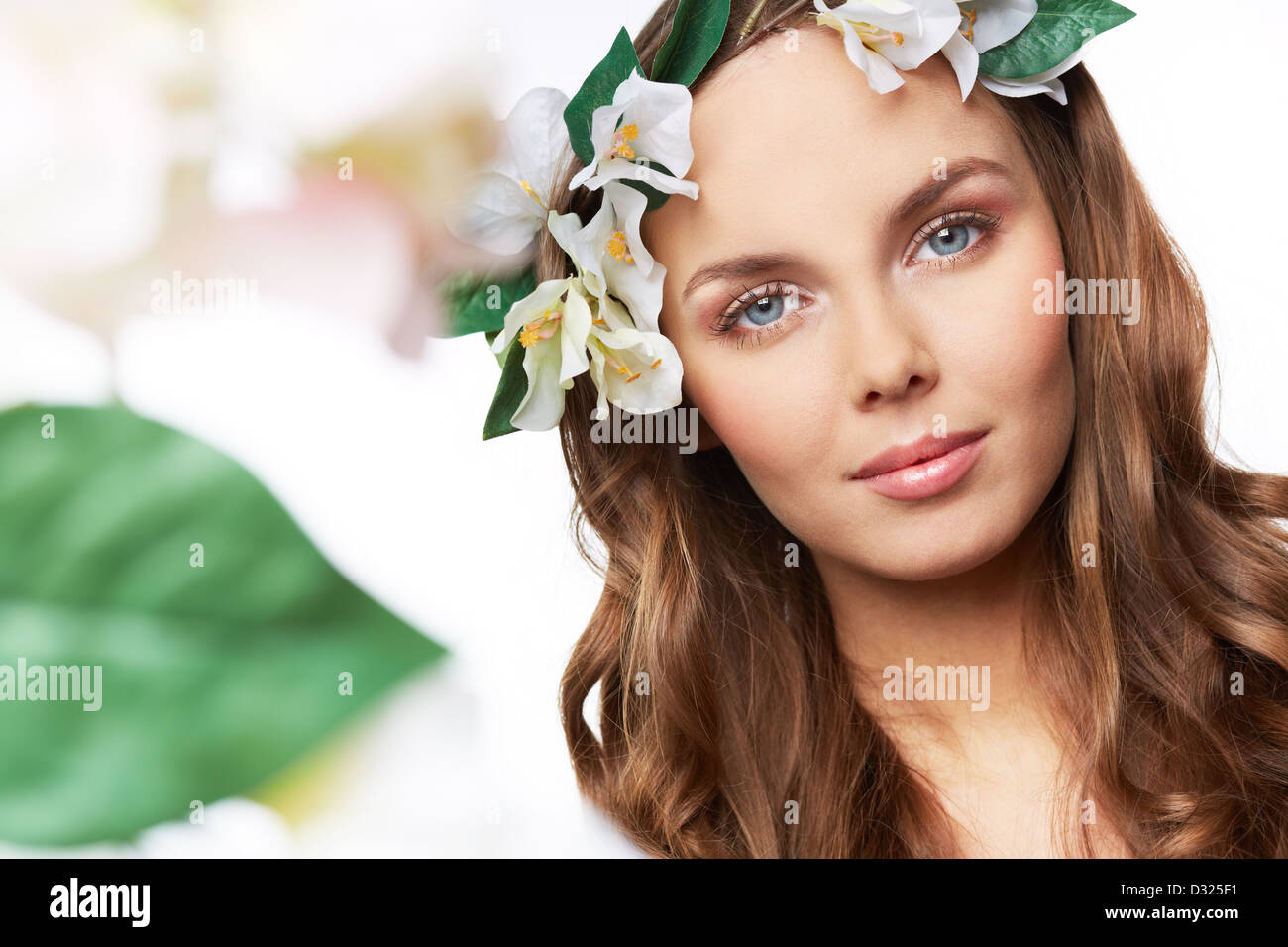 Portrait of a young model with lovely face and flowers in the hair ...