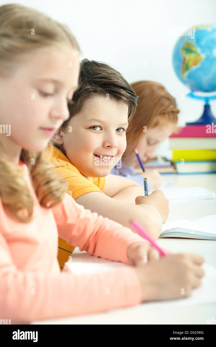 Portrait of smart schoolboy looking at camera between classmates Stock ...