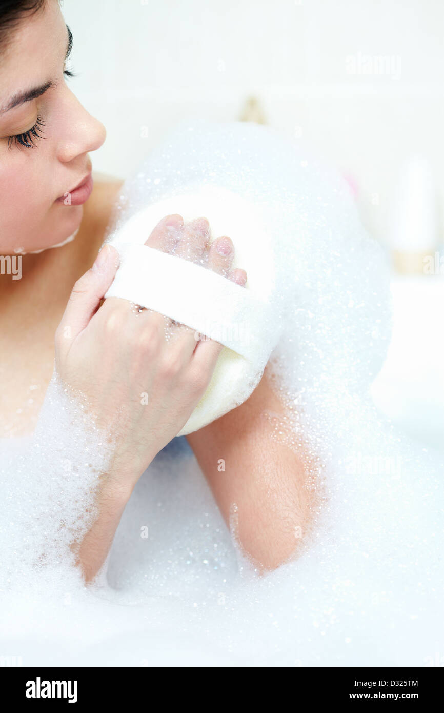 Image of young woman washing herself in bath with sponge Stock Photo ...