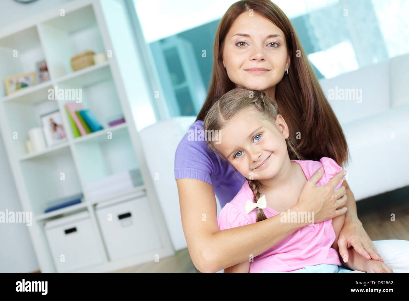 Mother and daughter looking at camera at home Stock Photo - Alamy
