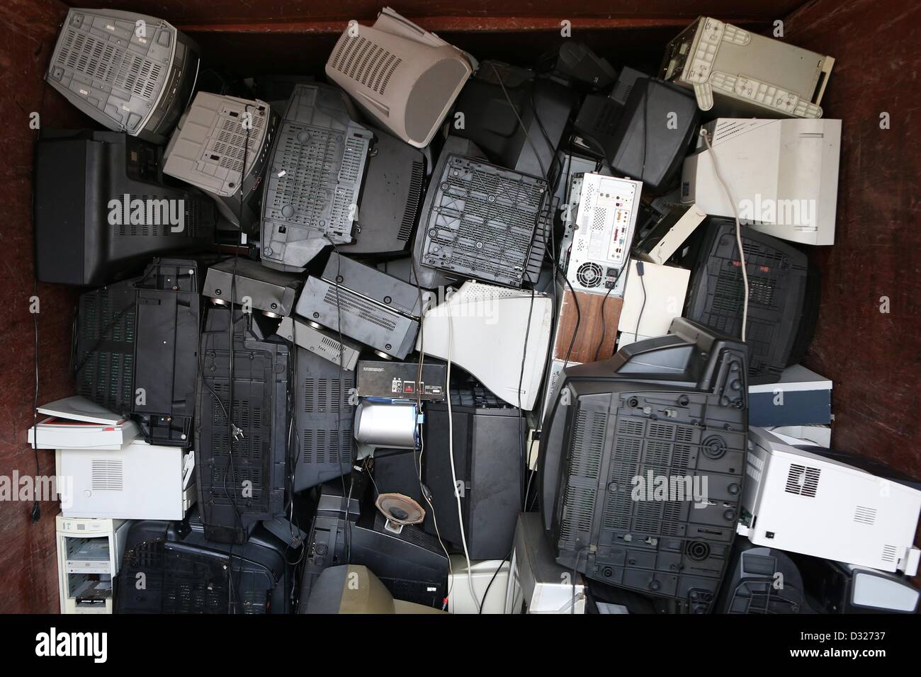 Discarded television sets and computer monitors are piled in a ...