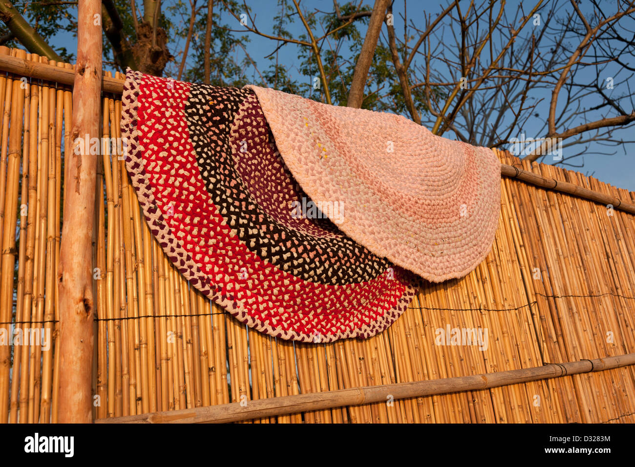 Colourful woven round mats hanging on a reed fence Stock Photo - Alamy