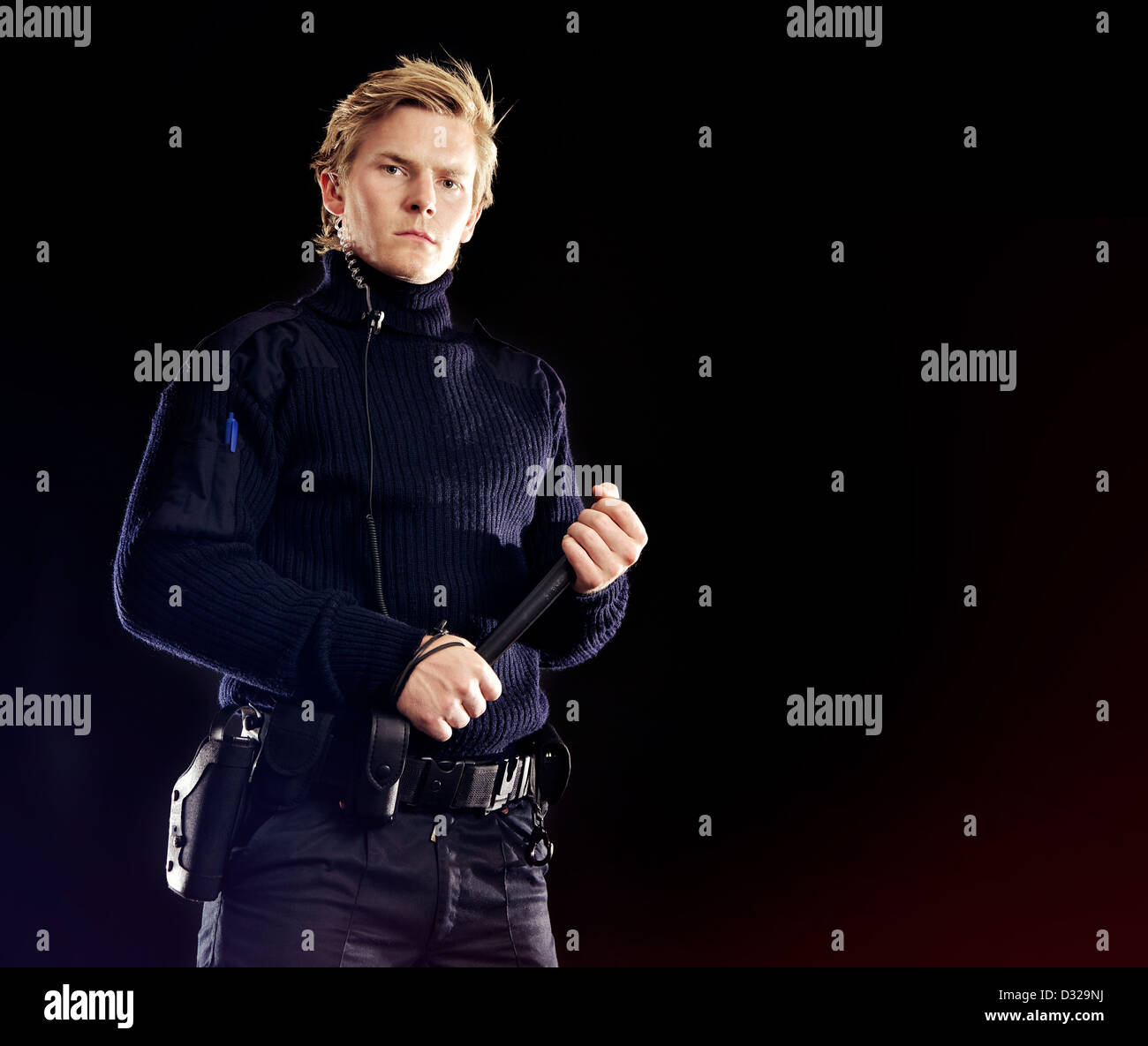 Handsome security officer with nightstick ensuring tough security for ...