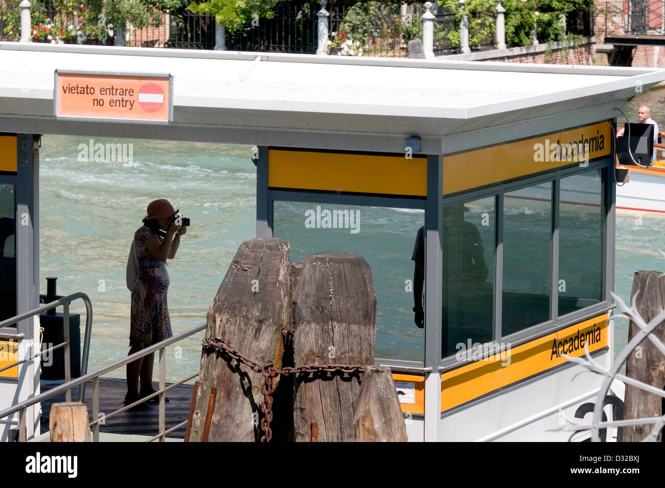 A tourist taking a picture on the Accademia vaporetto (water-bus) stop ...