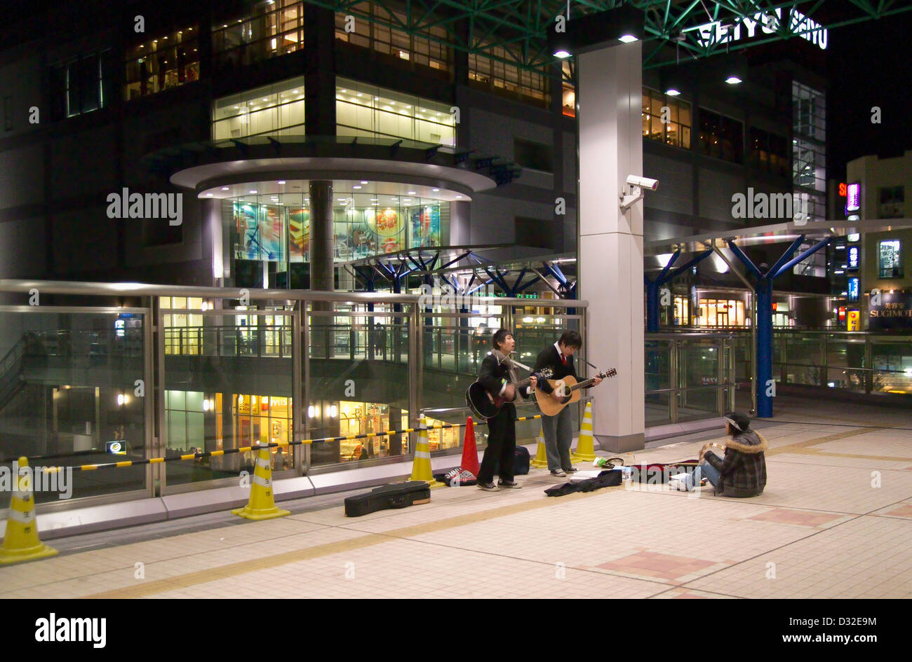 Street musicians perform at a railroad station in Japan, providing ...