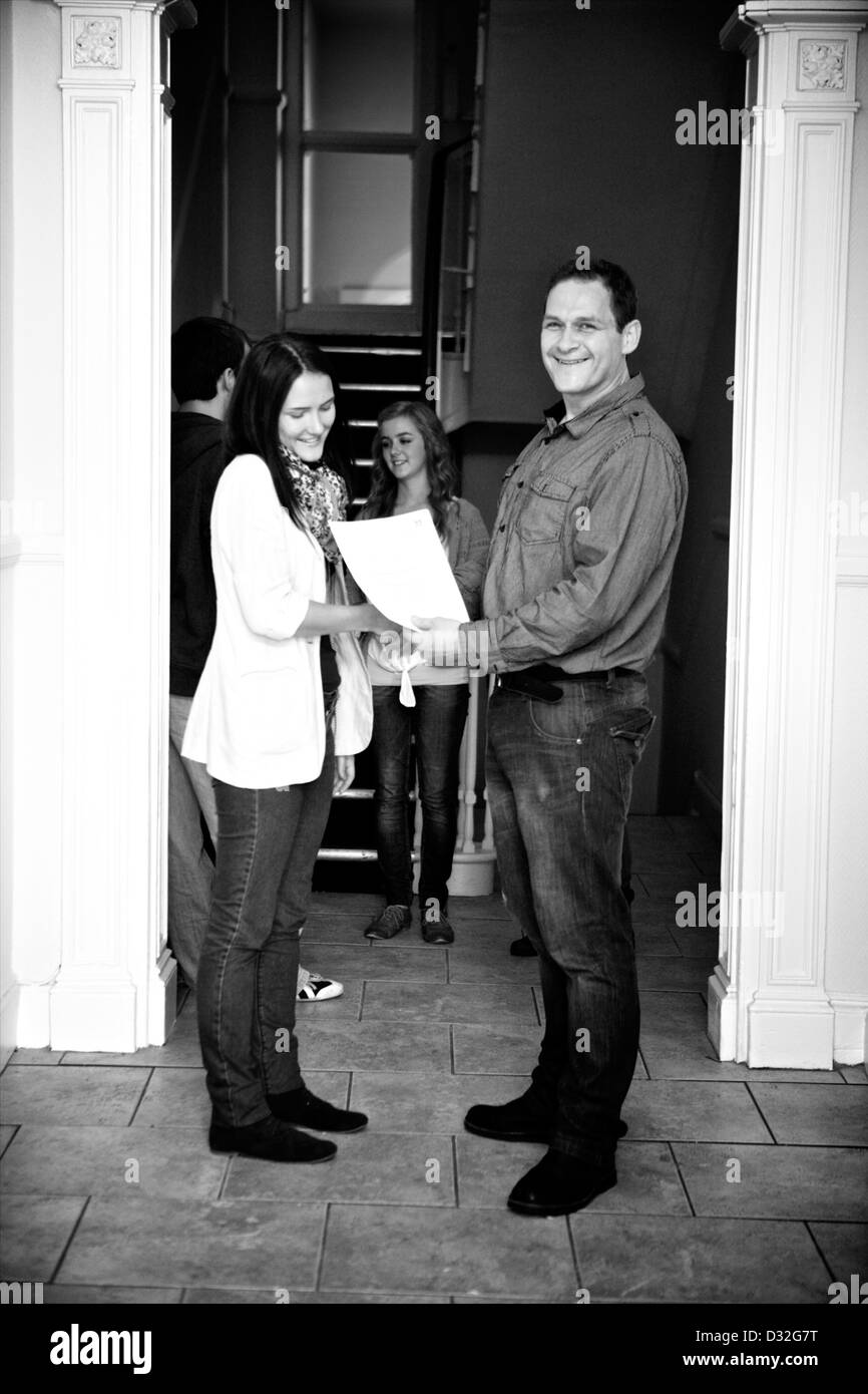 A young person being presented with their college degree having ...