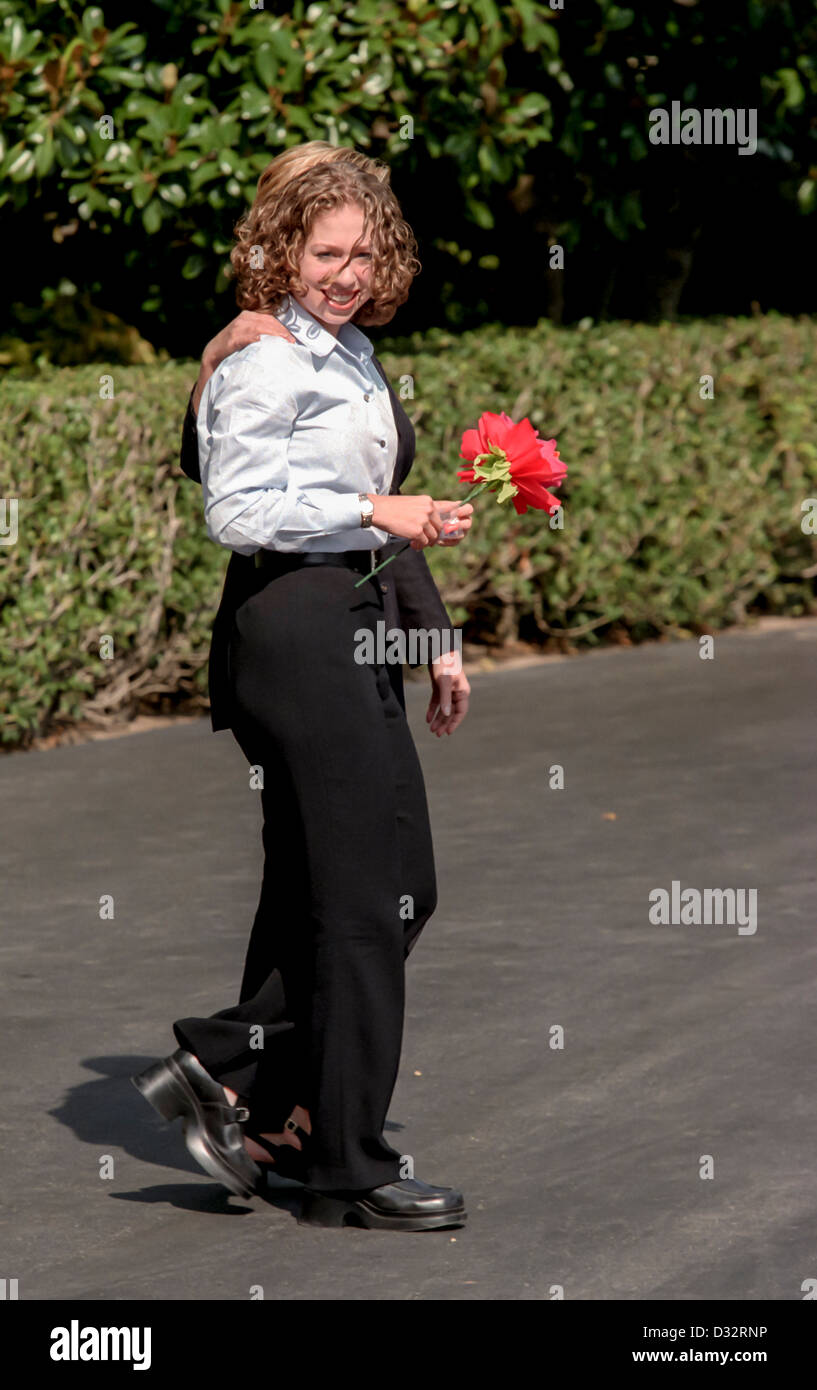 Chelsea Clinton holding a silk flower walks with her mother first lady ...