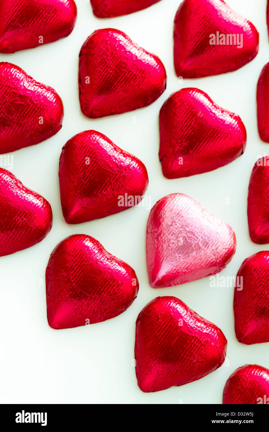 Heart shape chocolate candies wrapped in red foil for Valentine's Day ...