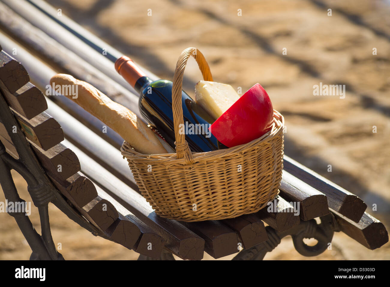 Sunny park bench with a full picnic basket Stock Photo - Alamy
