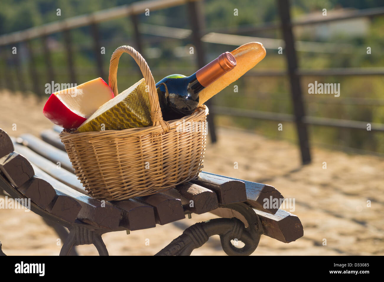 Sunny park bench with a full picnic basket Stock Photo - Alamy