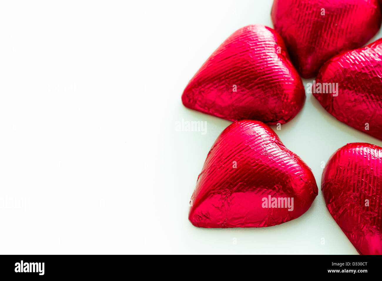 Heart shape chocolate candies wrapped in red foil for Valentine's Day ...