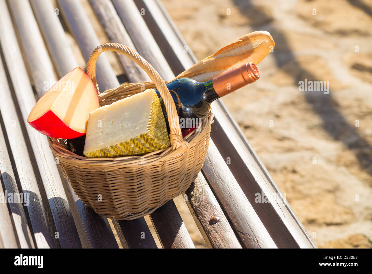 Sunny park bench with a full picnic basket Stock Photo - Alamy
