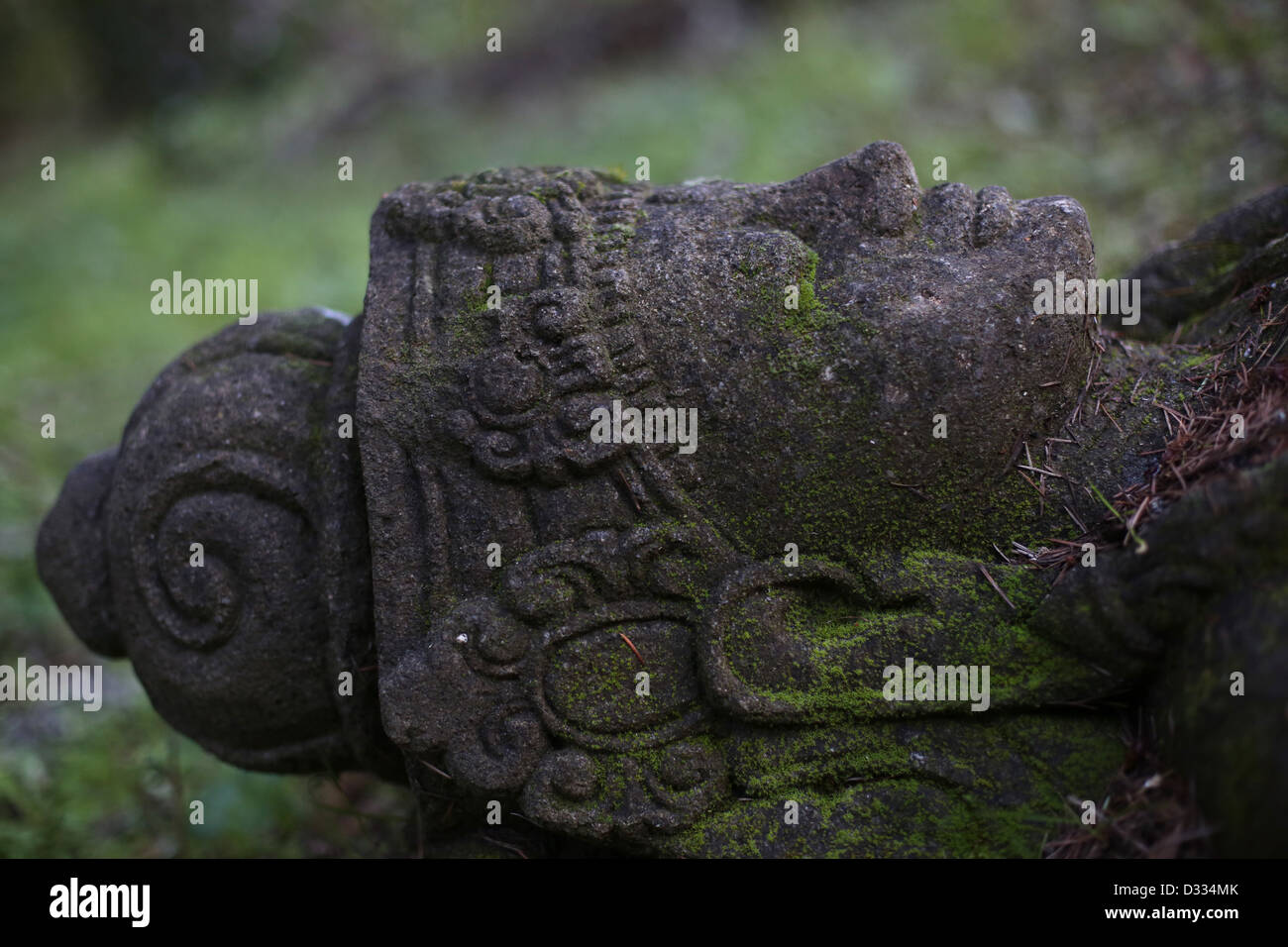 An old goddess statue covered with moss and lying down Stock Photo - Alamy
