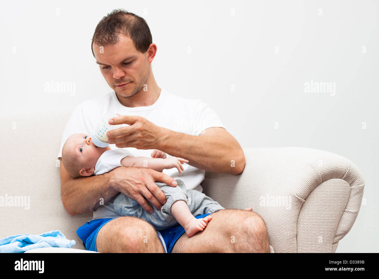 Portrait of a man feeding cute baby boy Stock Photo - Alamy