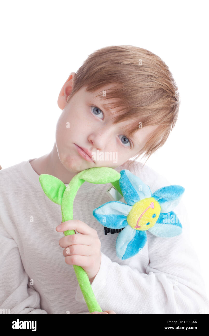 pouting sad but fresh looking boy holds drooping toy flower Stock Photo ...
