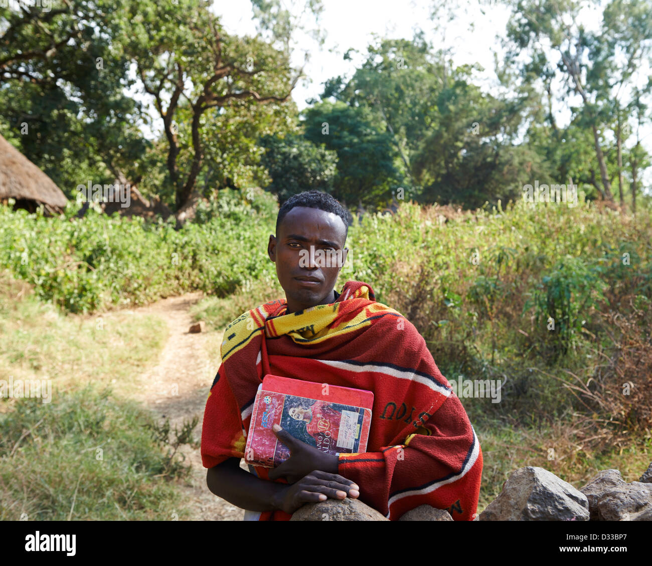 A local villager dressed in red and carrying books standing inside the ...