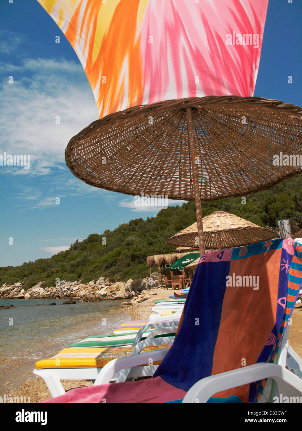 Lounge chair and parasol on a beach. Torba village, Bodrum peninsula ...