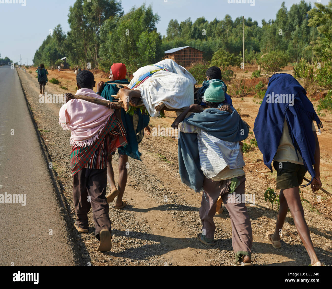 A sick man being carried on a stretcher by for men to the hospital ...