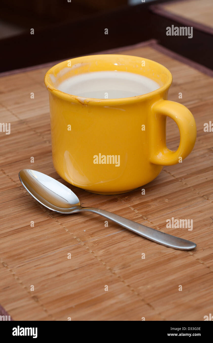 yellow mug with spoon Stock Photo - Alamy