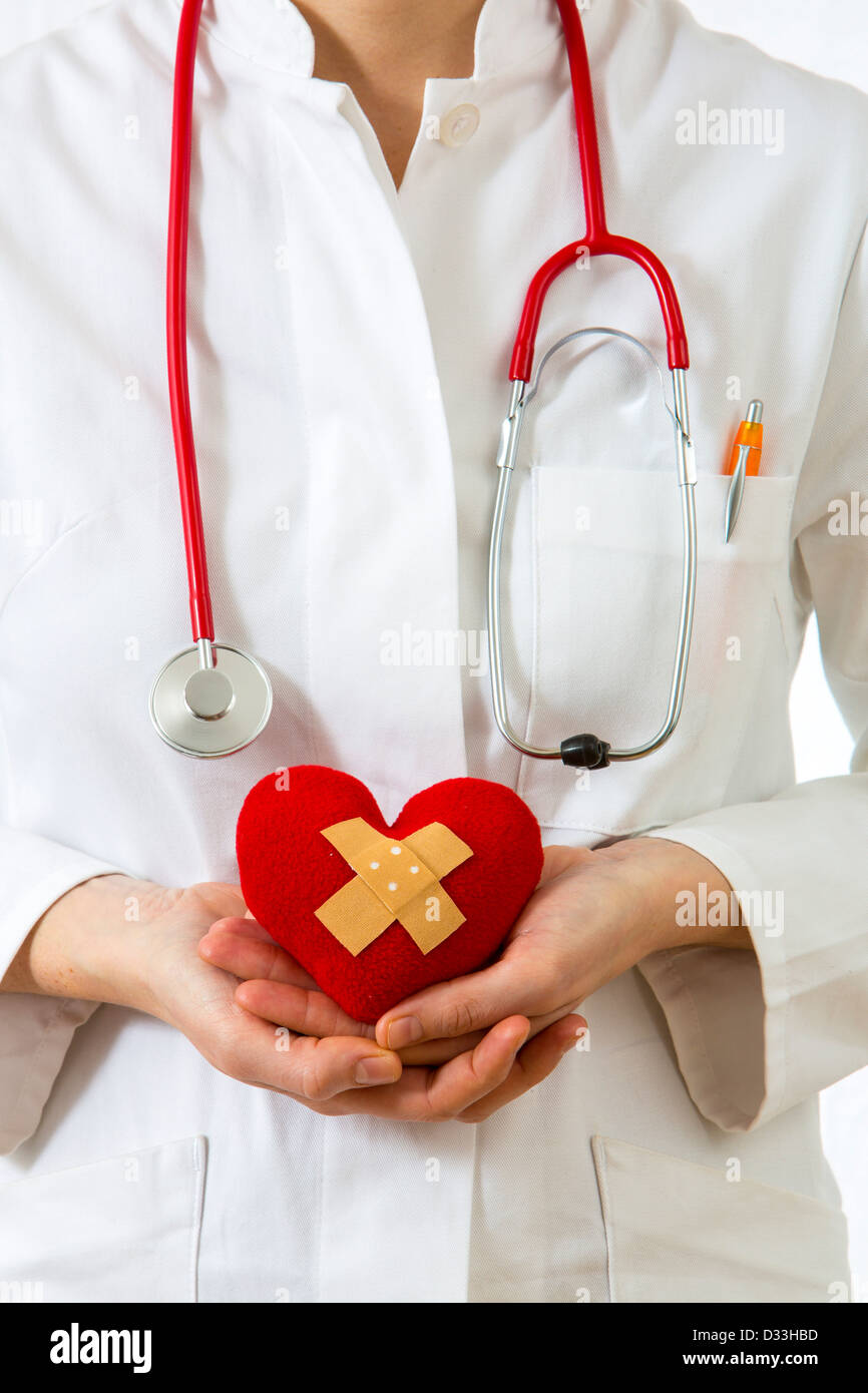 Symbol image, heart attack, medical. Doctor holding a red heart in her ...