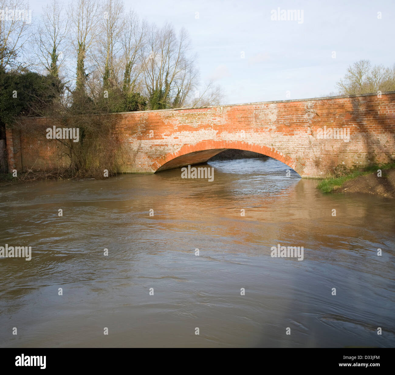 Red brick bridge spanning the swollen River Deben after heavy rain ...