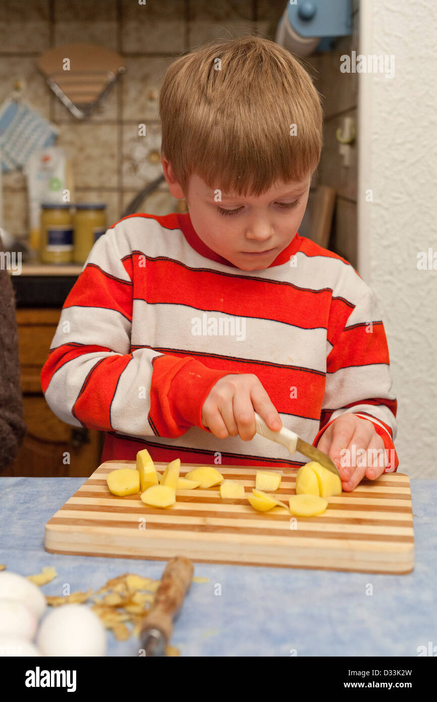 portrait of a young boy cutting potatoes Stock Photo - Alamy