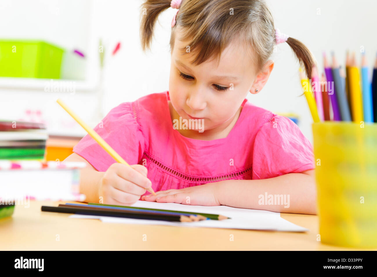Cute little girl drawing with colorful pencils at home Stock Photo - Alamy