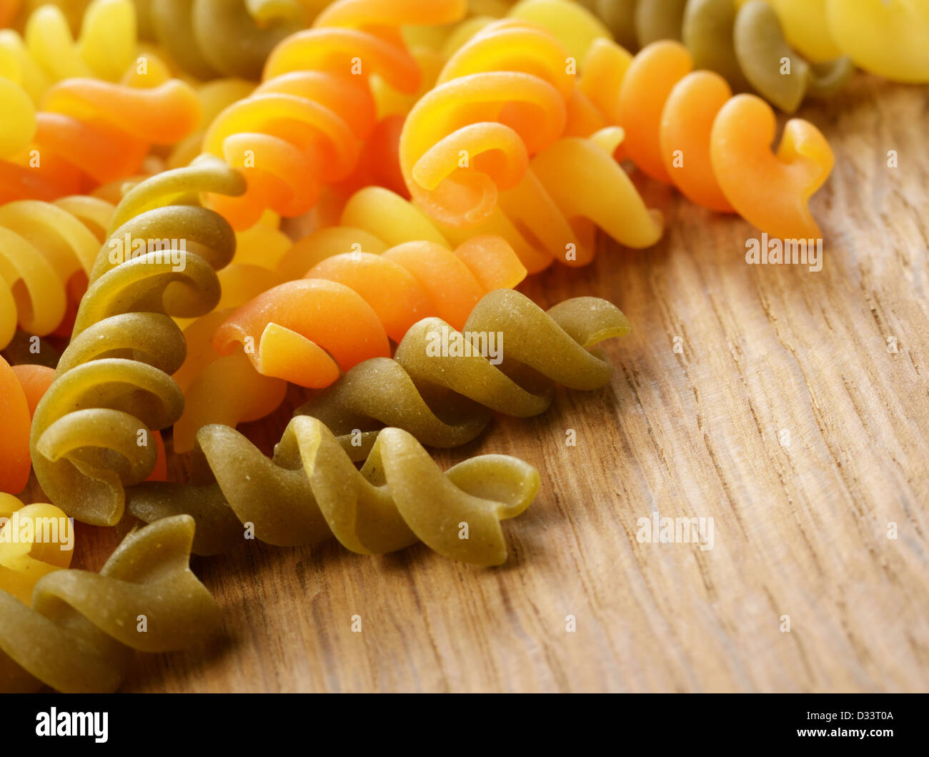 Tricolor fusilli pasta on the wooden table with copy-space Stock Photo ...