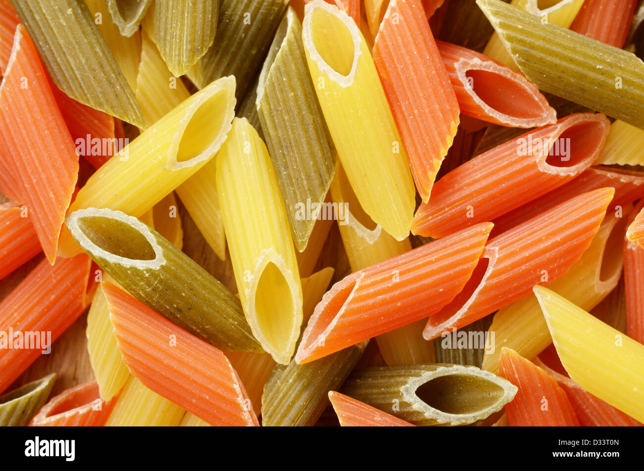 Raw tricolor pasta penne background Stock Photo - Alamy