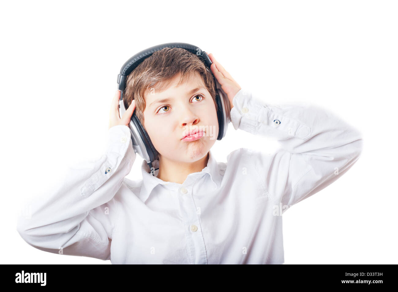 European school-age boy in a white shirt with headphones on white ...