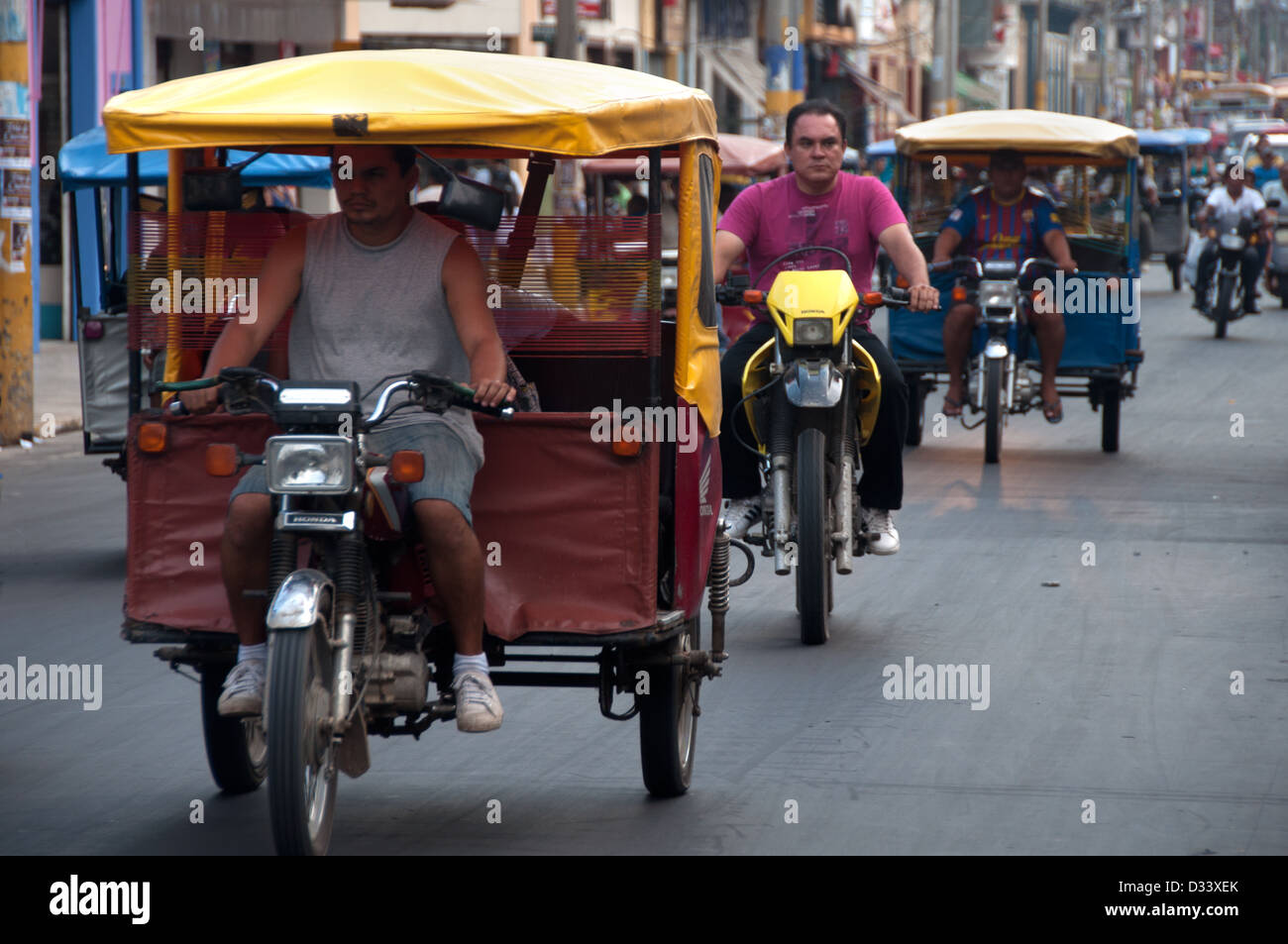Mototaxis and a motorcycle on the streets of Iquitos, Peru Stock Photo ...