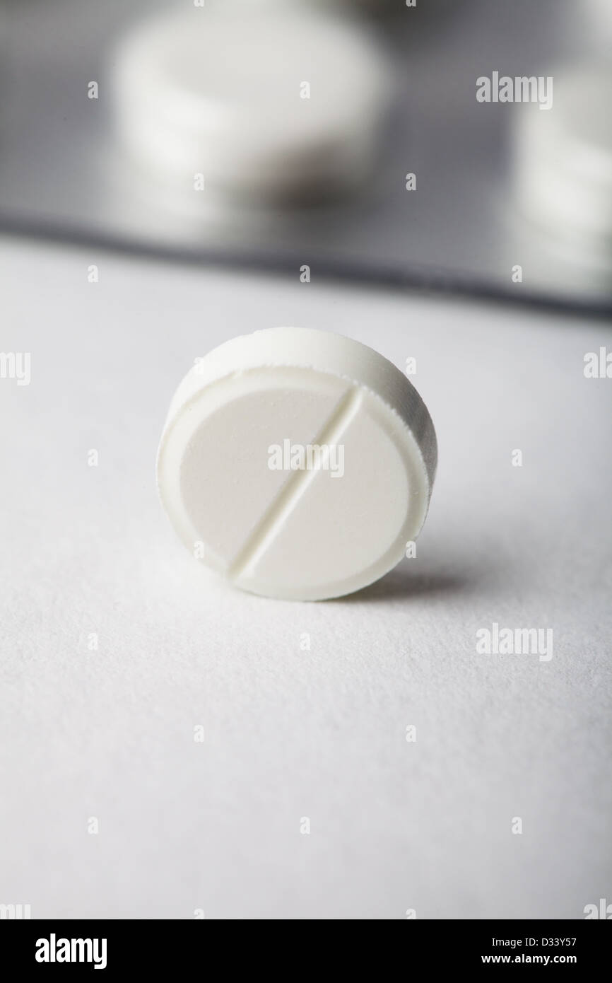 One tablet closeup on background with pack of pill Stock Photo - Alamy