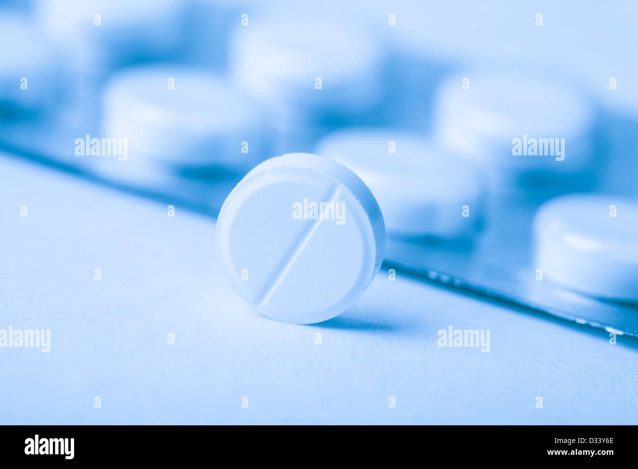 One tablet closeup on background with pack of pill Stock Photo - Alamy