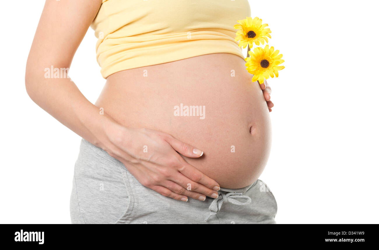 Woman's pregnant belly with two flowers Stock Photo - Alamy