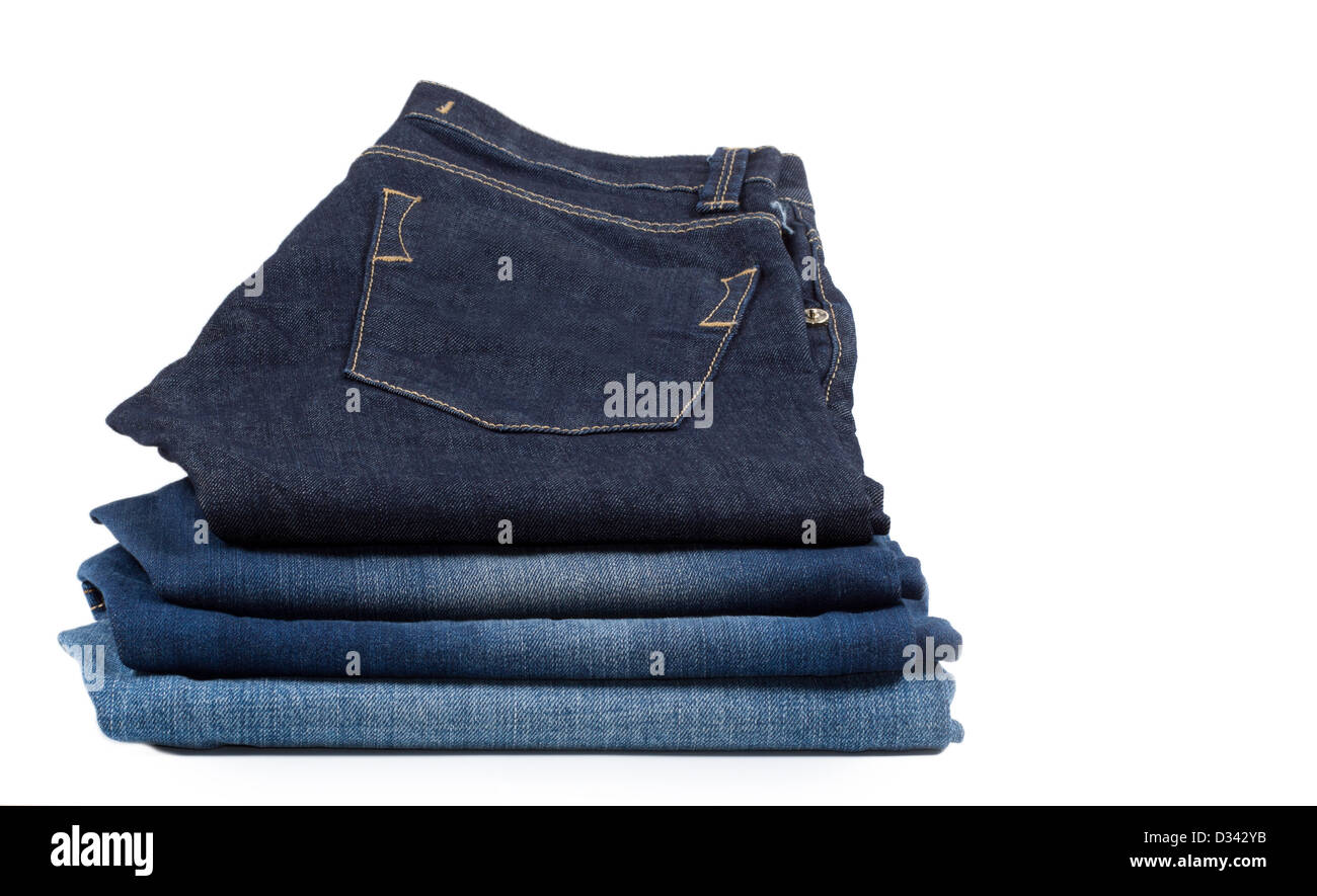 Pile of neatly folded denim jeans with the top pair lifted to display ...