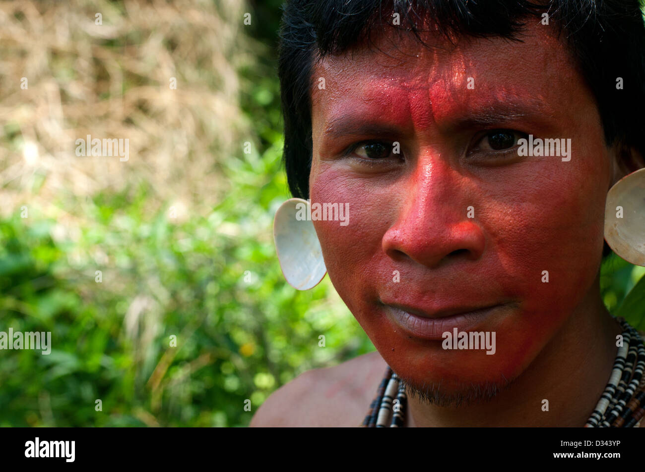A young Matis man with facial tattoos, shells at his ears, red paint ...
