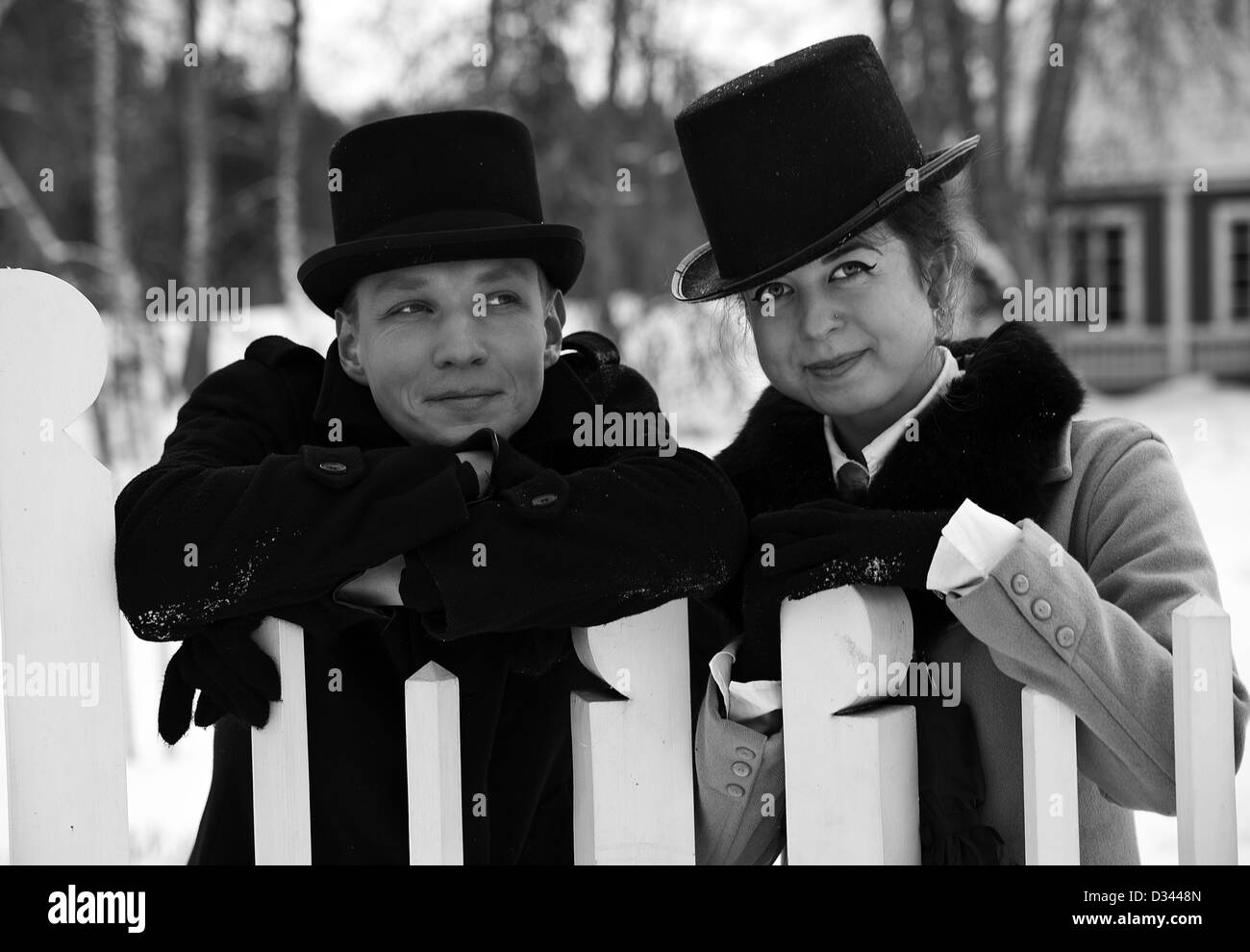 Shaded man and woman stand behind wooden fence Stock Photo - Alamy