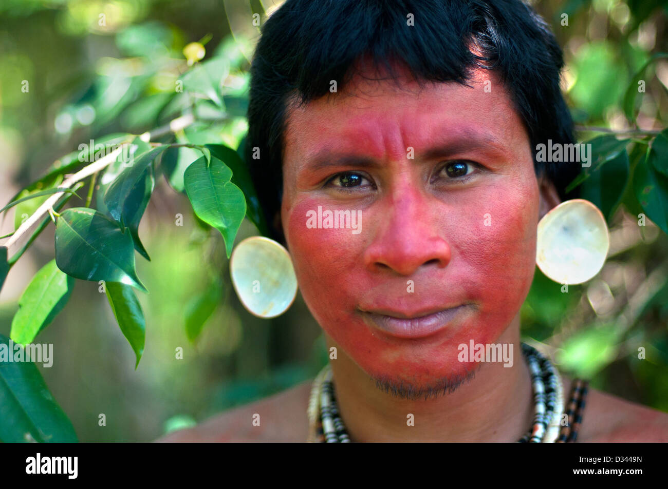 A young Matis man with facial tattoos, shells at his ears, red paint ...