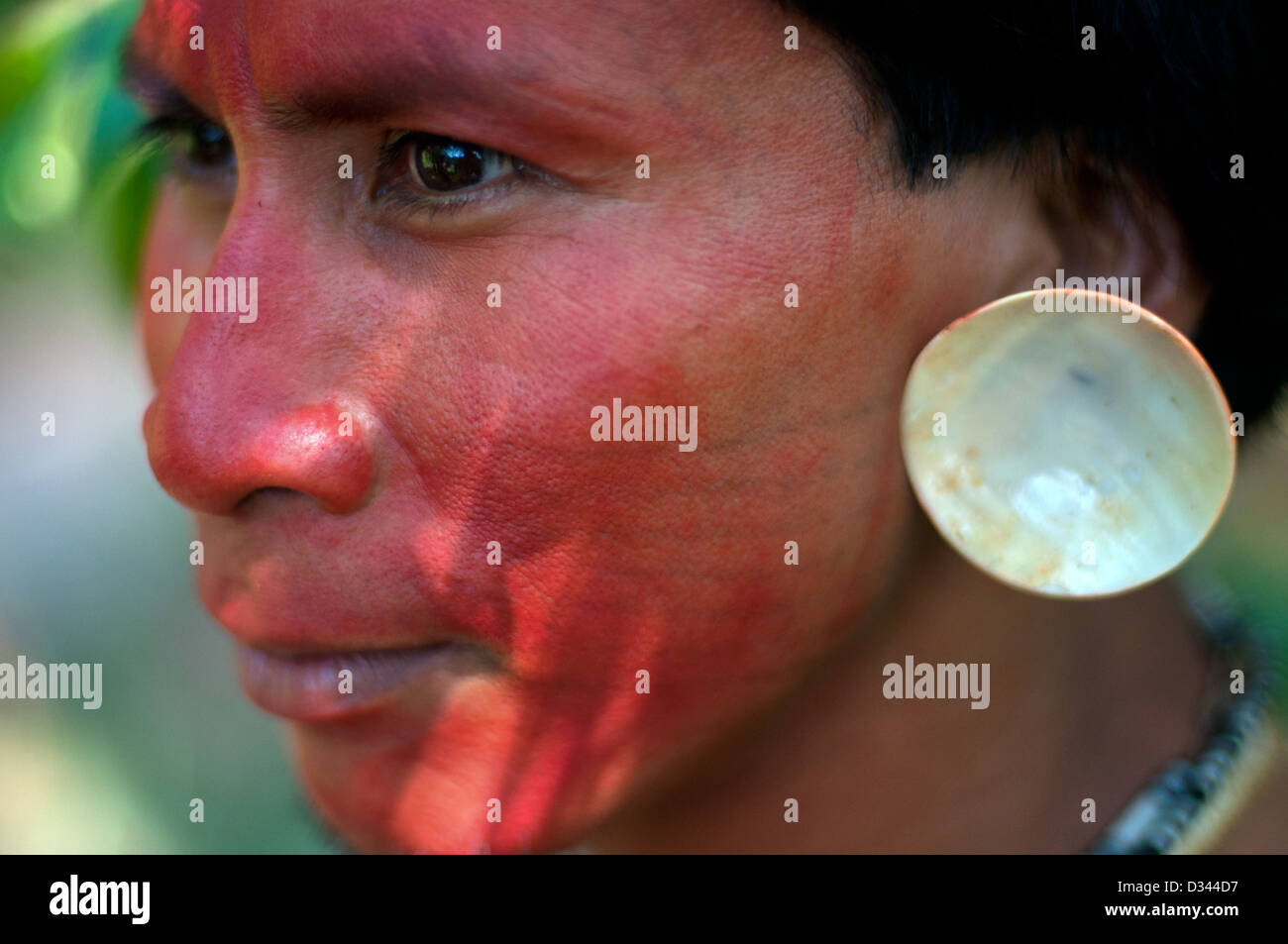 A young Matis man with facial tattoos, shells at his ears, red paint ...