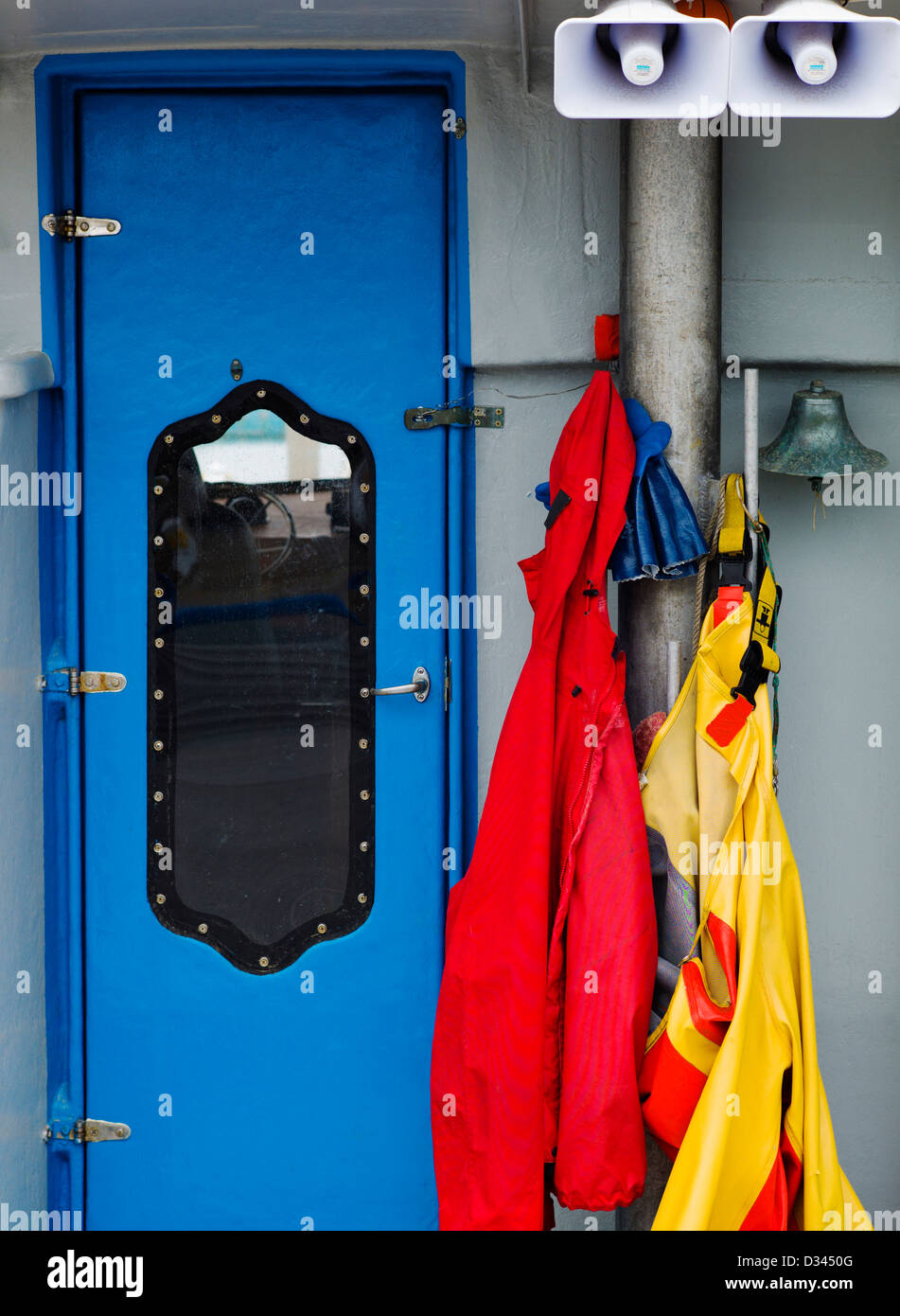 Rain coats and slickers hang on commercial fishing boat in the harbor ...