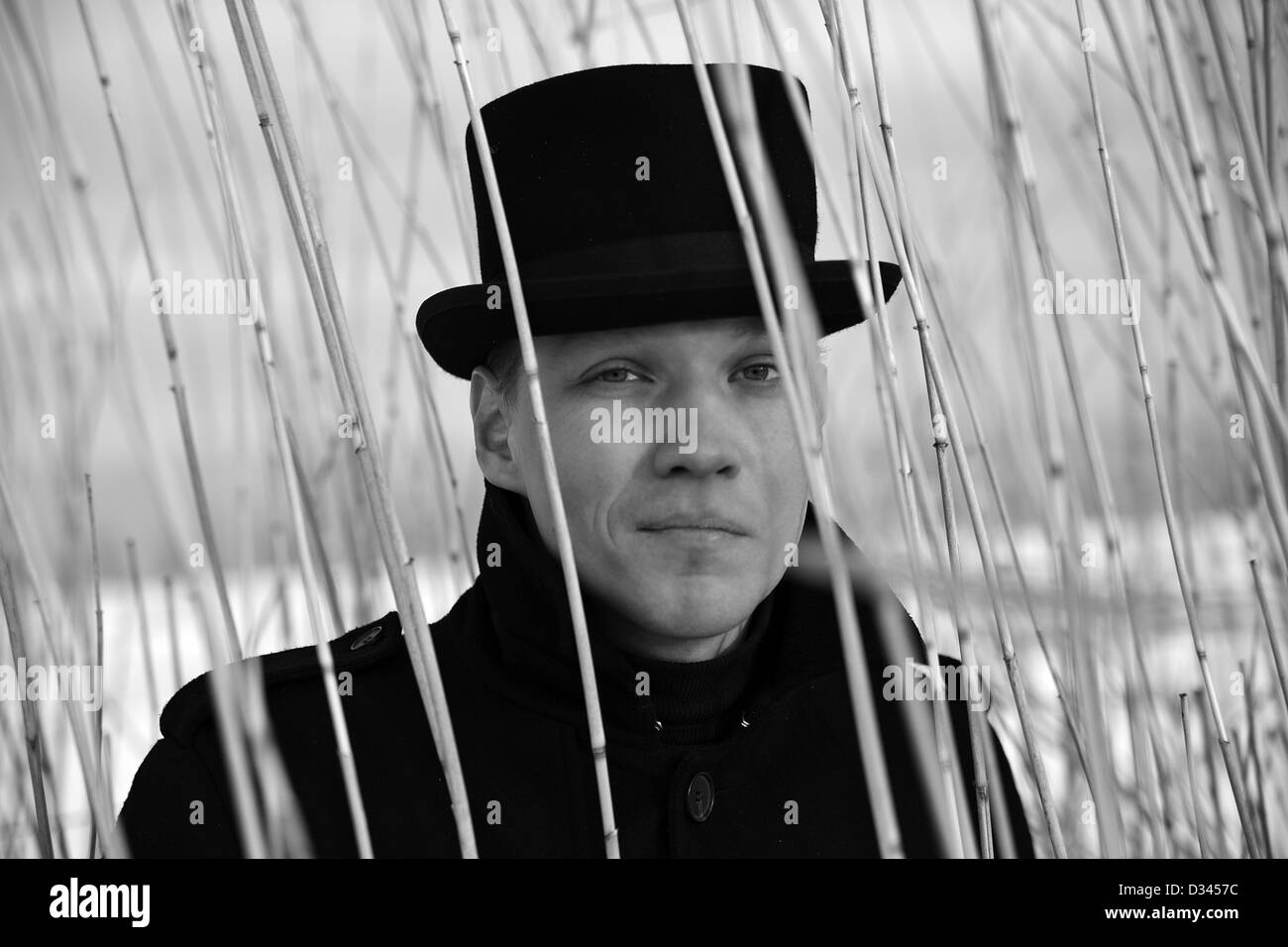 Shaded man looking through reed brush at winter Stock Photo - Alamy