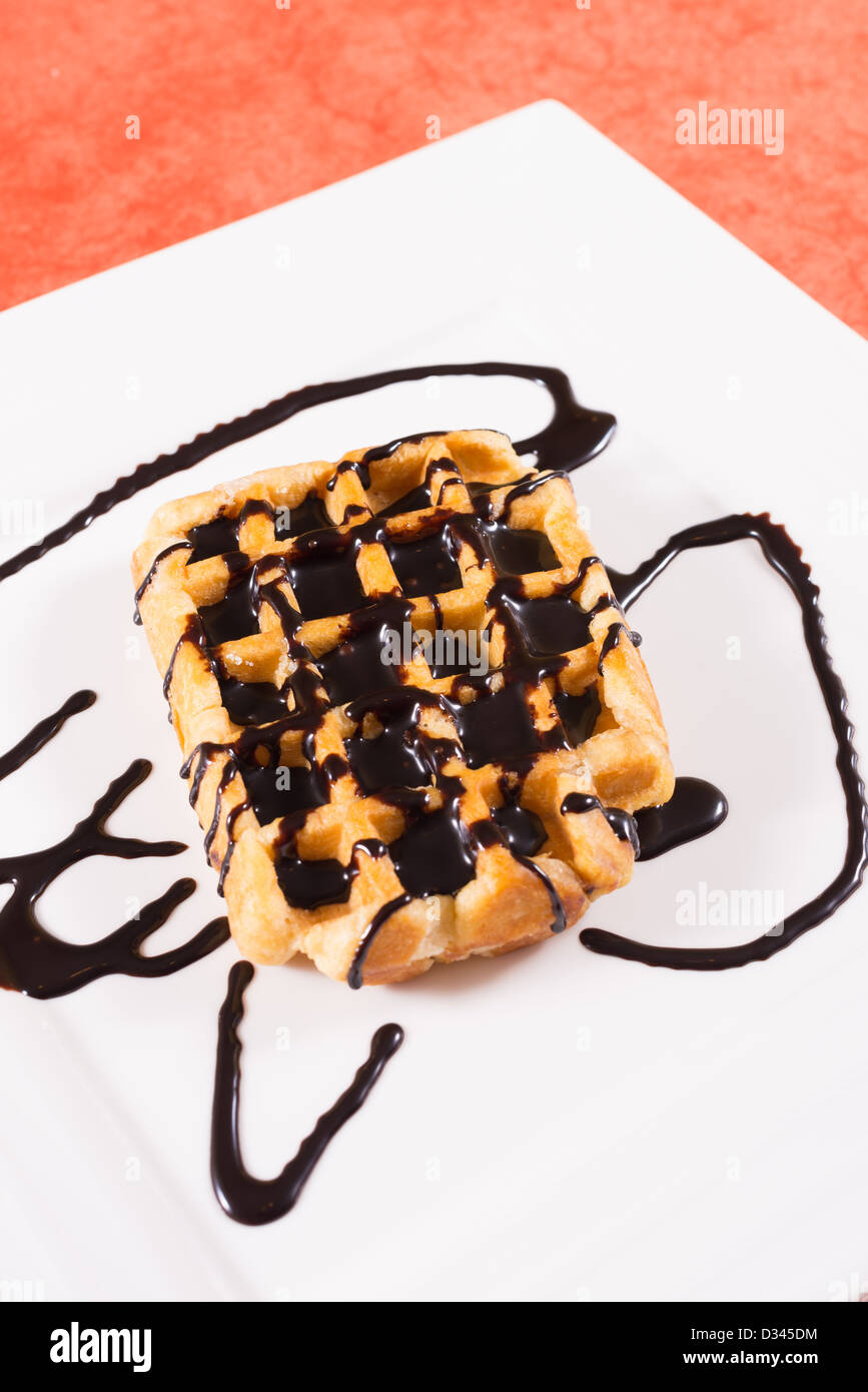 Freshly baked Belgian waffle with chocolate syrup Stock Photo - Alamy