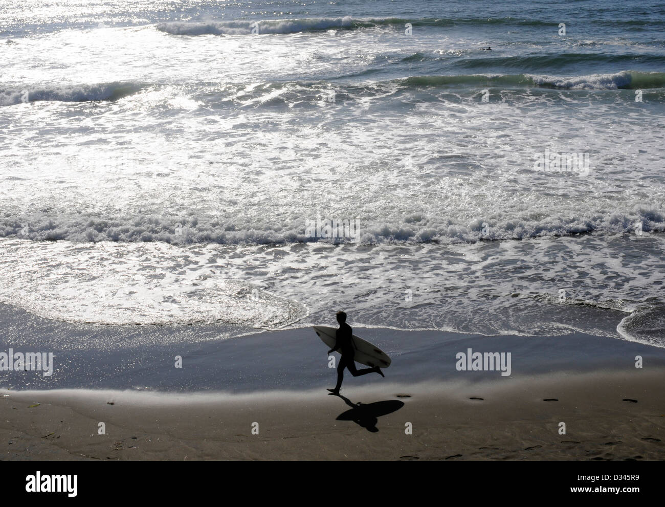 Surfer in wetsuit runs ocean hi-res stock photography and images - Alamy