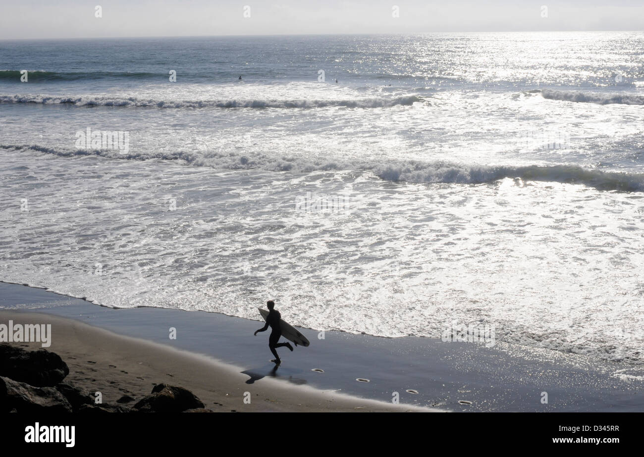 Surfer in wetsuit runs ocean hi-res stock photography and images - Alamy